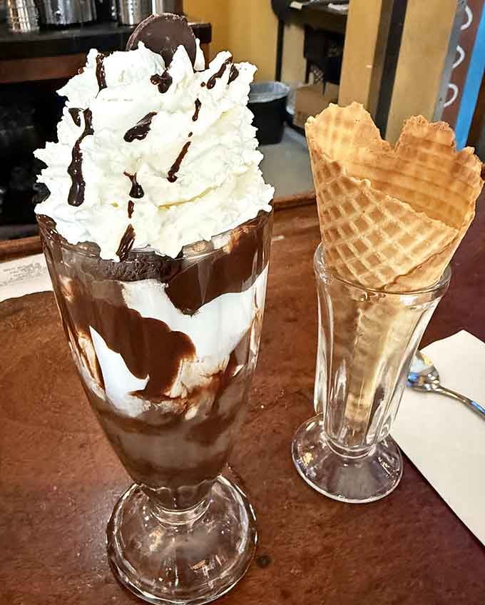 This towering sundae situation comes with layers of chocolate, whipped cream, and pure joy in every spoonful.