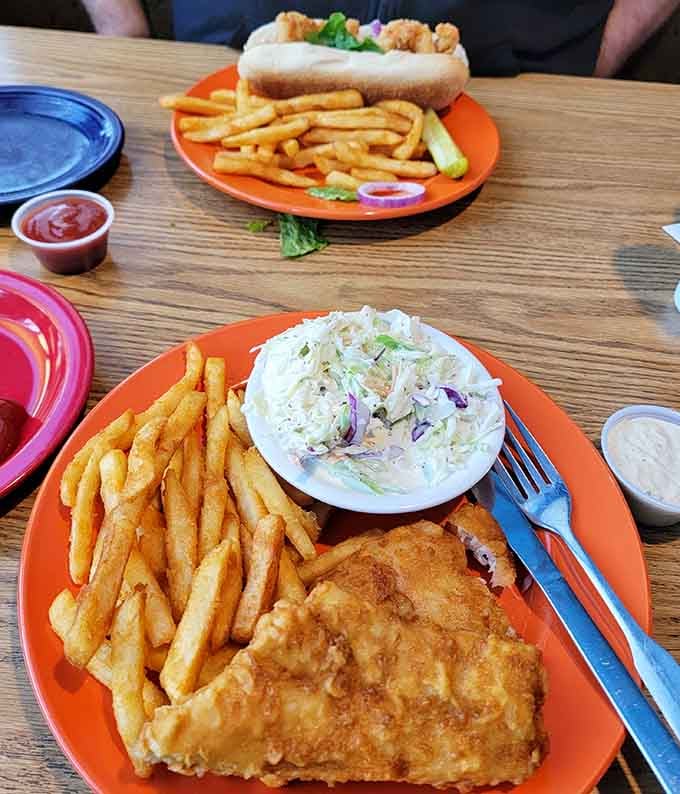 Behold the golden standard by which all other fish and chips shall be judged, served on cheerful orange plates.