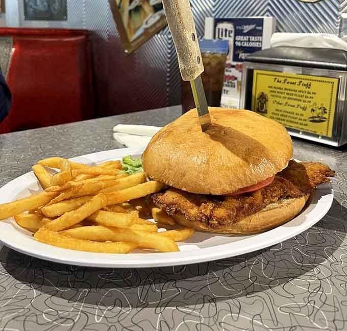 Golden-fried chicken on a toasted bun with crispy fries delivers simple perfection on a plate.