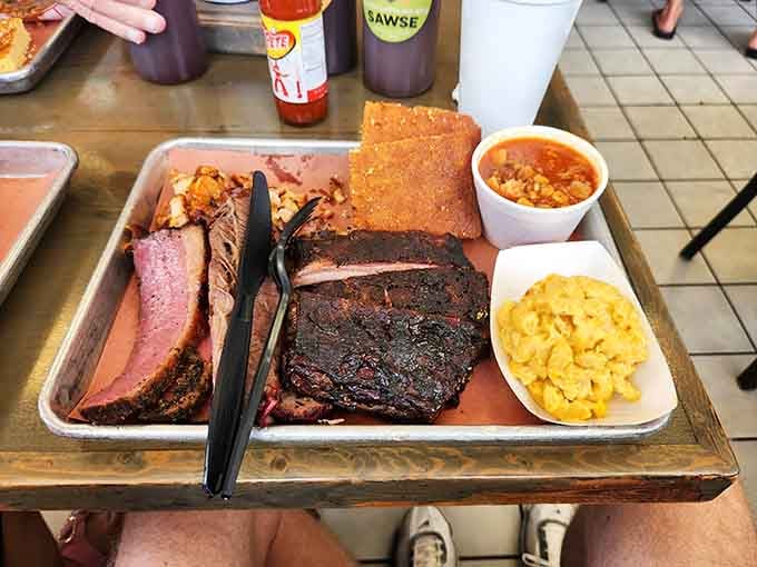 This tray holds more championship-level meat than most people see in a lifetime: brisket, ribs, and sides worth the trip.