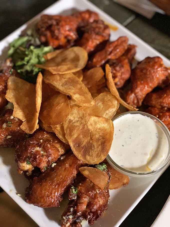 Golden wings with house-made chips and ranch dressing prove that sometimes the classics just need better execution.