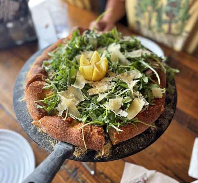 Fresh arugula and shaved parmesan crown this beauty like nature's confetti on perfectly baked dough.