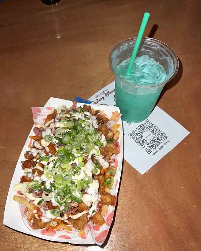 Loaded fries piled high with toppings and paired with a turquoise drink that's basically liquid happiness.