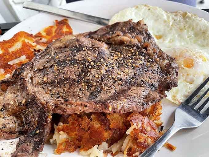 That ribeye steak sitting next to perfectly cooked eggs is basically the breakfast equivalent of winning the lottery.