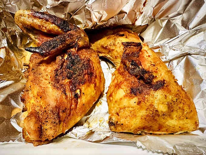 Golden-skinned BBQ chicken emerges from the kitchen with char marks that promise serious flavor ahead.