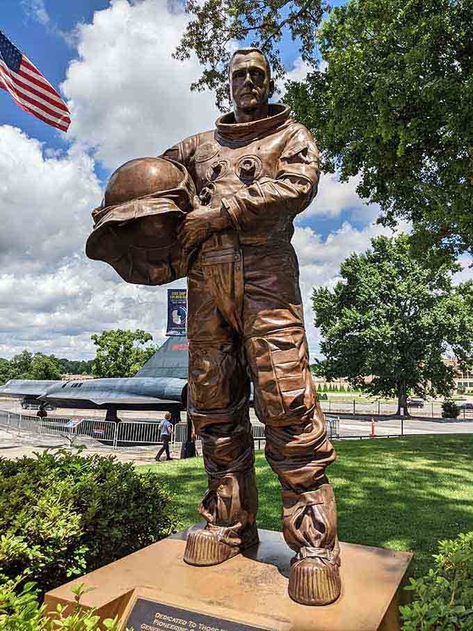 This bronze astronaut stands ready for launch, helmet tucked under arm like he's just running to the corner store.