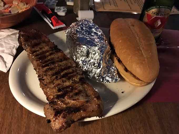 Behold your handiwork: a perfectly grilled steak with foil-wrapped potato, the fruits of your labor shine.