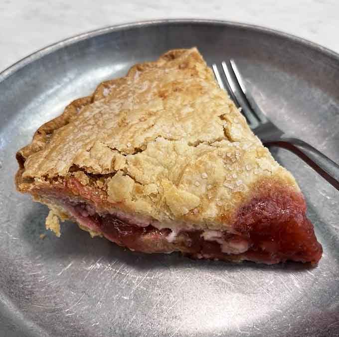 Strawberry rhubarb pie with a crust so flaky it could teach a masterclass in buttery perfection and fruit balance.