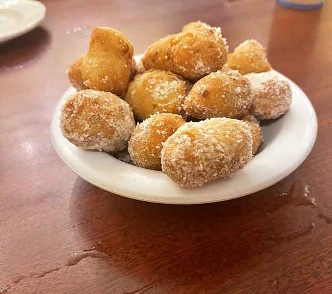 Golden corn fritters dusted with sugar, because sometimes the appetizer deserves to steal the whole show completely.