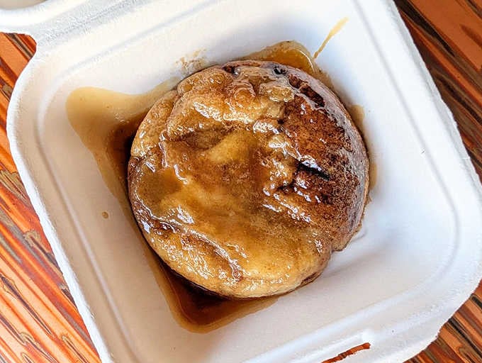 Behold the sticky bun that launched a thousand U-turns, swimming in its own caramel glory pool.