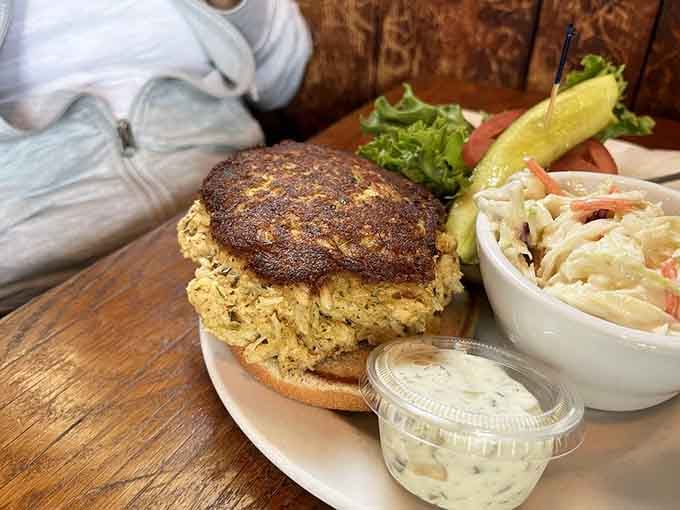 Behold the crab cake that launched a thousand road trips, perched majestically on its bun like edible architecture.