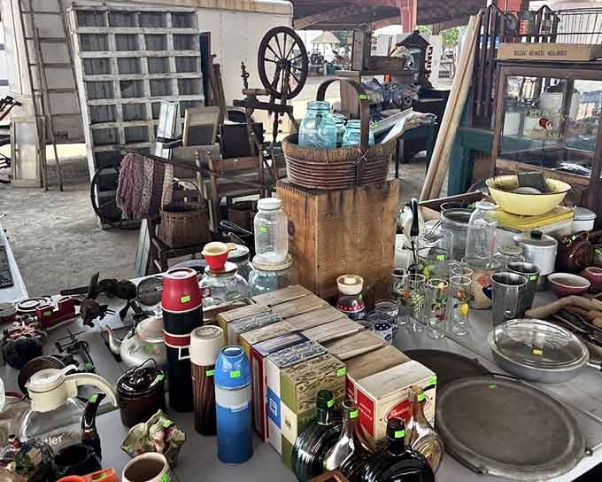 Spinning wheels, vintage thermoses, and colorful glassware create a nostalgic tableau that would make any collector's heart skip.