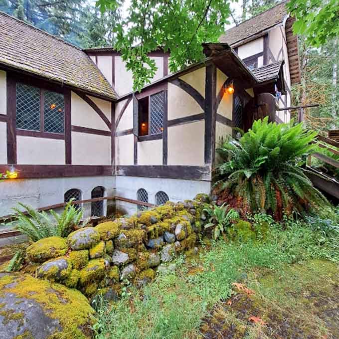 Tudor beams and diamond-paned windows emerge from the forest like a fairy tale cottage waiting to be discovered.