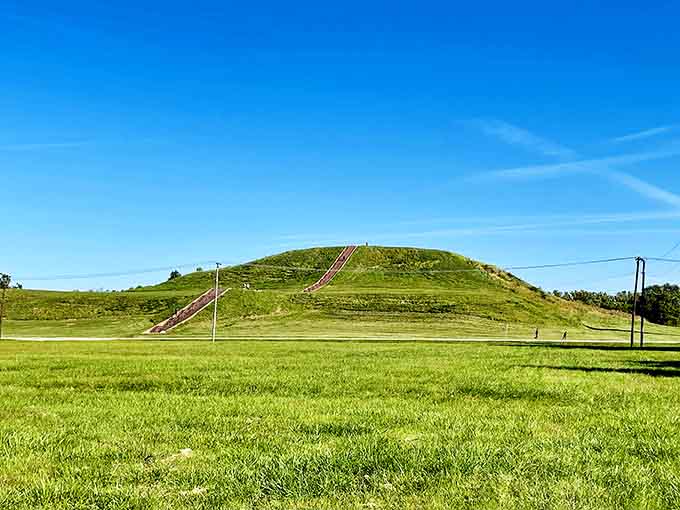 This grass-covered mound rises from the prairie like a green pyramid, stairs climbing toward history written in earth and sky.