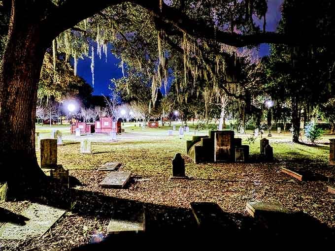 Spanish moss drapes the oaks like nature's curtains while tombstones stand guard beneath the evening's purple glow.