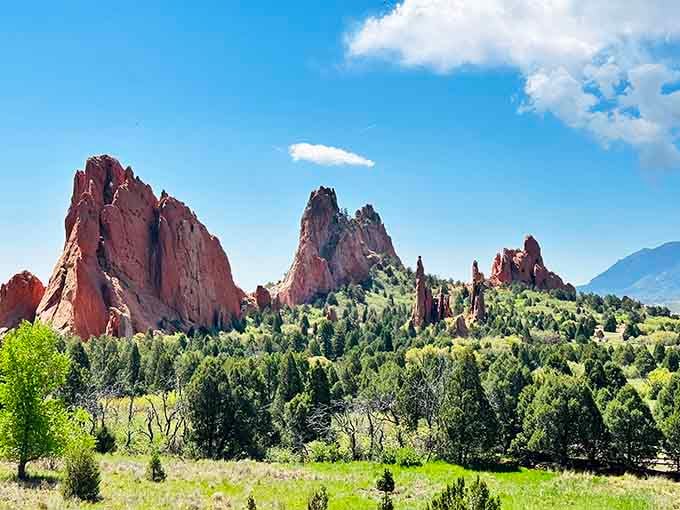 These crimson rock formations rise like ancient cathedrals, their weathered faces glowing against impossibly blue skies in timeless majesty.