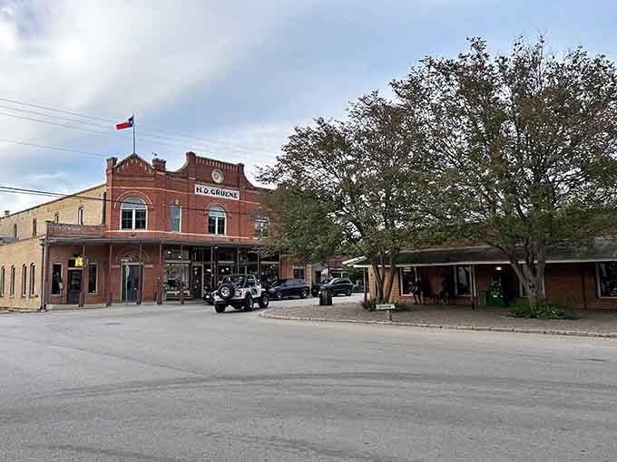 The historic brick storefront beneath that spreading oak tree whispers stories of generations who've walked these same sidewalks.