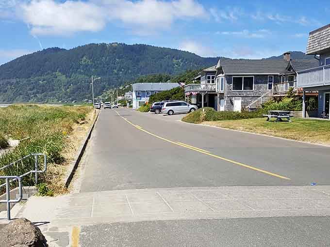 Sandy paths wind through beach grass toward glowing homes at twilight, creating pure coastal magic and serenity.
