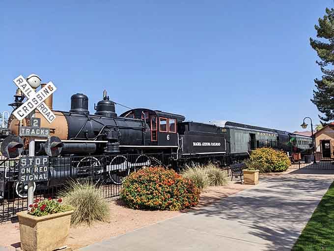 This magnificent steam locomotive stands proud behind vintage crossing signals, a monument to the golden age of rail.