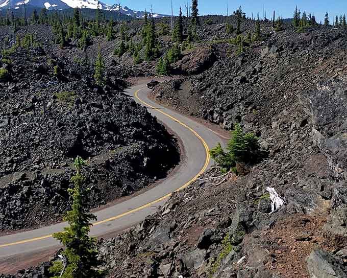 The highway ribbons through ancient lava fields, black volcanic rock creating an otherworldly moonscape all around.