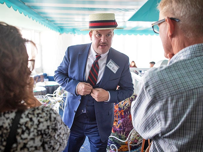 That dapper fellow in the boater hat means business—murder mystery business, where everyone's a suspect.