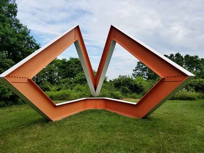 This bold orange sculpture frames the sky like modern art decided to give nature a high-five.