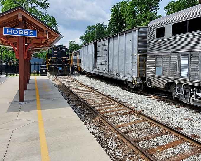 The Hobbs station platform stretches alongside vintage rail cars, inviting passengers to step into railroad history today.