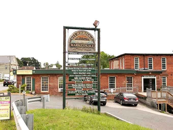 The charming Sturbridge Marketplace sign welcomes seekers of yesteryear, where brick buildings hold secrets from decades gone by.