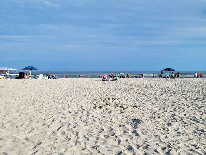 Blue umbrellas dot the shoreline like cheerful sentries guarding families enjoying their slice of coastal heaven together.