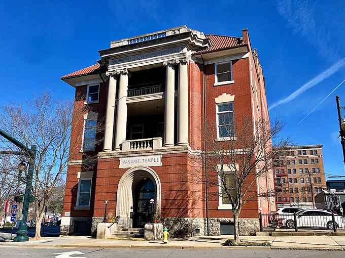 This stately brick building with grand columns whispers stories of history while standing proud against the clearest blue sky.