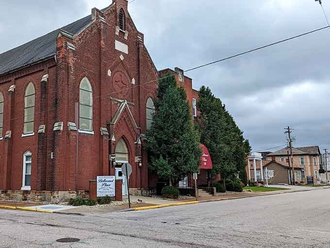 Red brick Gothic arches frame evergreen trees&mdash;a former church now repurposed, proving old buildings can find new life beautifully.