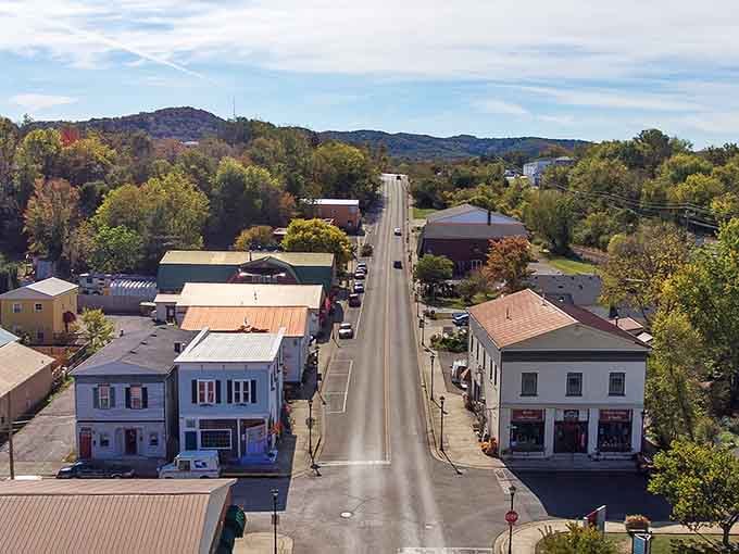 Main Street stretches toward rolling hills where small-town charm meets mountain views in one perfect postcard scene.