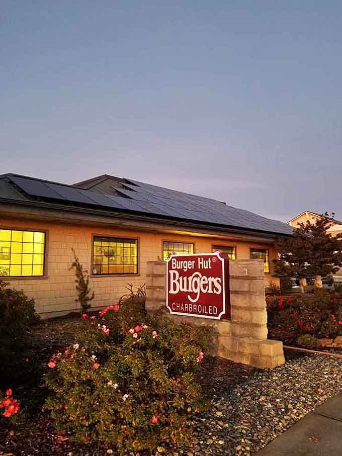 Evening light bathes the building in golden warmth while roses bloom cheerfully in the well-tended garden beds.