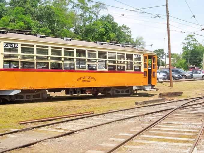 The Boston Elevated Railway car stretches along multiple tracks, showcasing the impressive length of vintage urban transit vehicles.