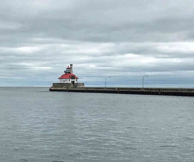 Storm clouds gather over the pier where this sturdy beacon stands watch, dramatic as any Hitchcock film backdrop.