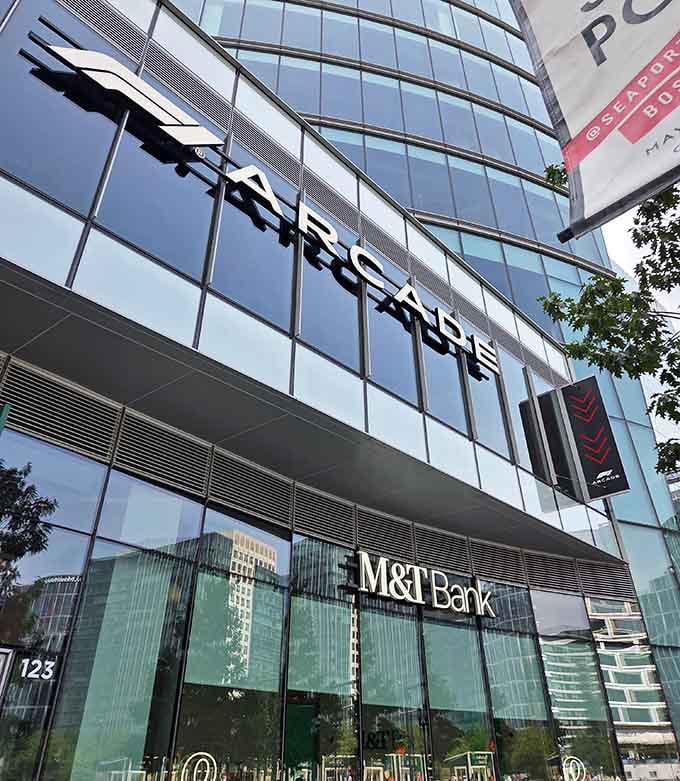 The towering F1 Arcade sign promises high-octane thrills just beyond those gleaming waterfront windows ahead.