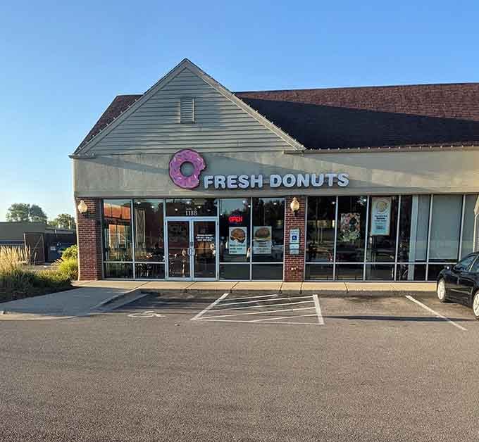 The peaked roofline and generous windows create an inviting atmosphere where fresh donuts meet small-town charm every single morning.