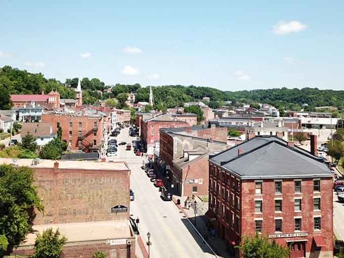 From above, the town unfolds like a storybook with red brick buildings nestled among green hillsides.