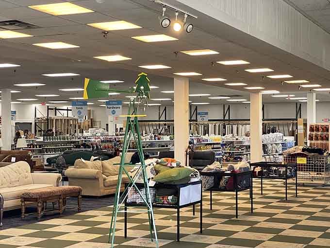 That vintage green ladder standing tall among the furniture creates an oddly perfect snapshot of eclectic thrift store magic.