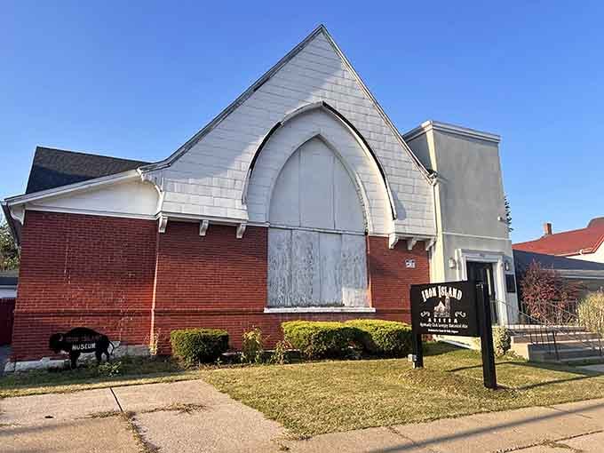 The weathered Gothic entrance and manicured hedges create an intriguing contrast between past mysteries and present-day care.