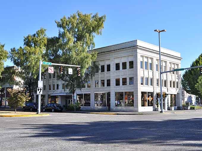 That white corner building catches the eye like a lighthouse, standing tall and elegant among its colorful downtown neighbors.