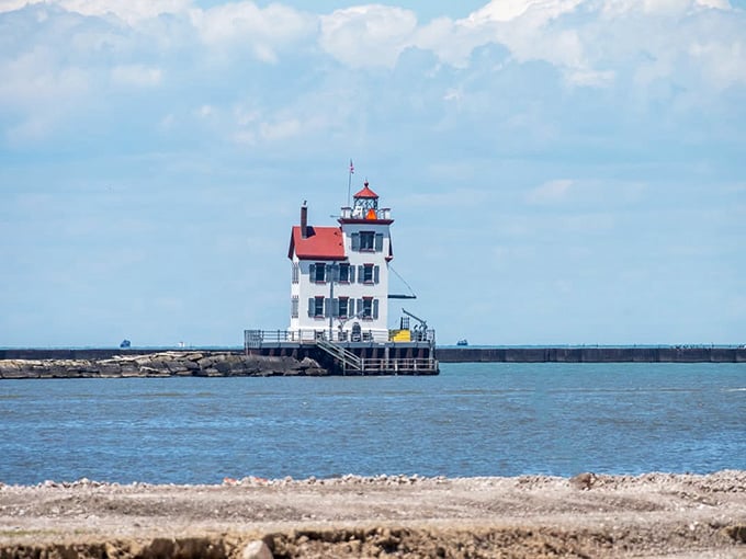 Gentle waves lap at the rocks while this stately lighthouse stands watch like a faithful friend.
