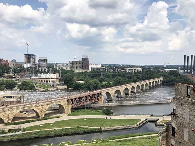The historic Stone Arch Bridge curves gracefully across the water, connecting past and present with timeless elegance.