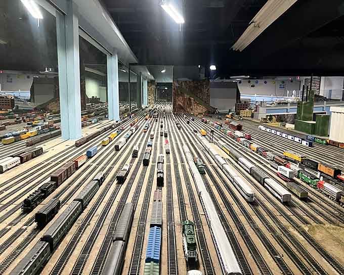 Endless rows of tiny trains crisscross this massive space, creating a hypnotic ballet of locomotives that defies belief.