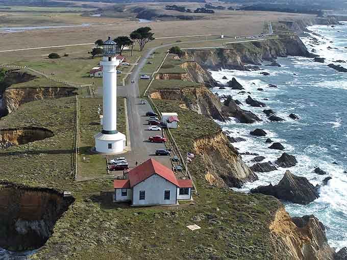 The bird's-eye view reveals how this lighthouse complex sits perfectly positioned between rolling farmland and crashing Pacific surf.