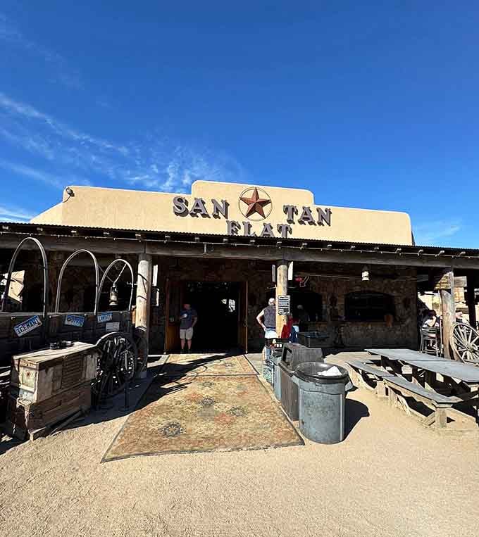 The entrance pathway lined with vintage farm equipment welcomes you to an outdoor dining experience that's pure desert magic.