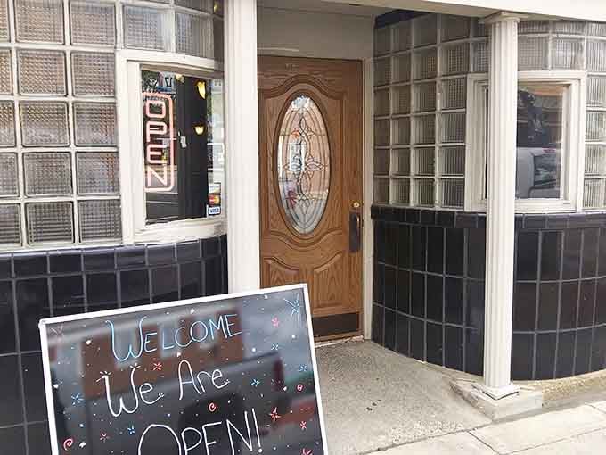 That welcoming wooden door and cheerful chalkboard sign say "come on in, friend"&mdash;small-town hospitality at its absolute finest.