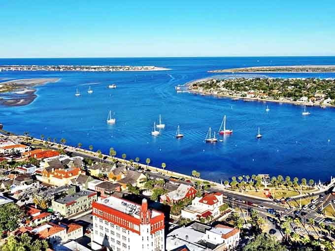Sailboats dot the harbor like confetti while St. Augustine's historic charm spreads across the landscape in warm hues.