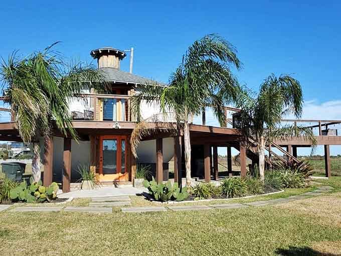 Palm trees frame this kettle-shaped dwelling perfectly, blending quirky architecture with practical hurricane-resistant design beautifully.