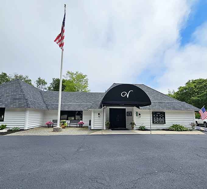 An American flag waves proudly above this charming white building where classic steakhouse traditions meet northern Michigan hospitality.